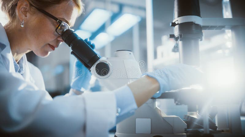 Bright Medical Science Laboratory: Beautiful Microbiologist Looks Under ...