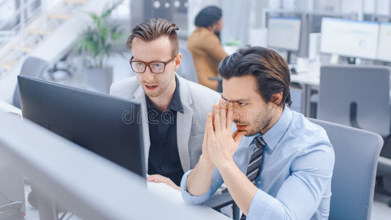 In Bright Modern Office: Handsome Office Worker Sitting and Working at ...