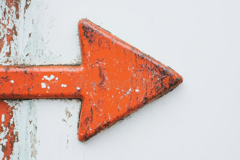 Bright Orange Arrow Pointing Right on a Weathered White Wall during ...
