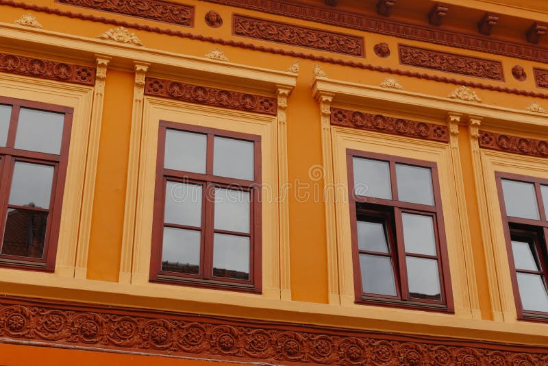 Bright Orange Building with Decorative Window Frame Details and a ...