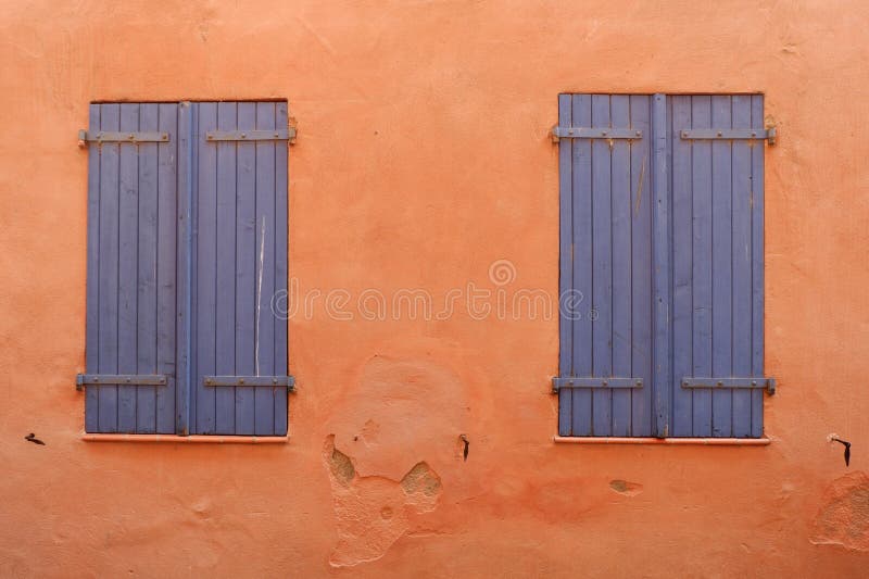 Bright Orange Wall Features Two Worn Blue Shutters, Adding a Rustic ...
