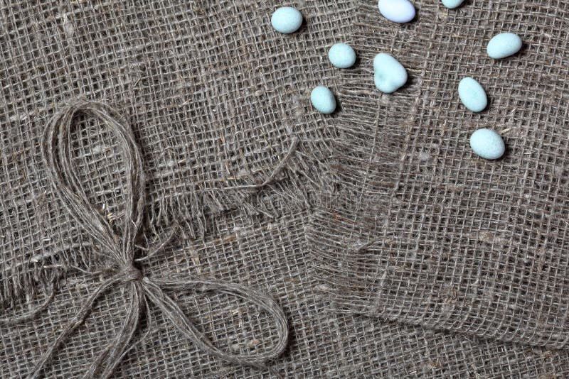 Bright Pebbles Lie on a Rough Linen Fabric. Near a Bow of Linen Thread ...