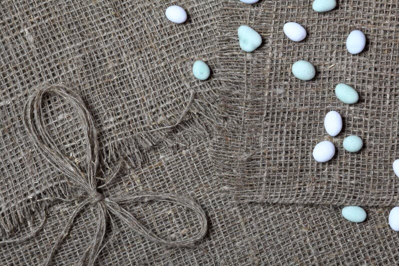 Bright Pebbles Lie on a Rough Linen Fabric. Near a Bow of Linen Thread ...
