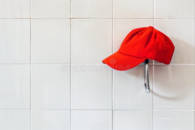 Bright Red Cap on a Sleek Silver Hook Against a White Tiled Wall Stock ...