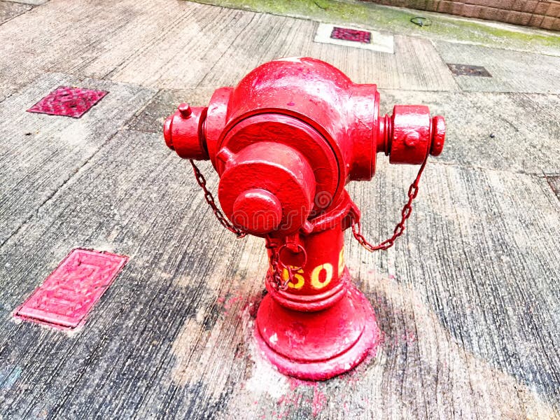 A Bright Red Fire Hydrant Stands on a Concrete Sidewalk, with a Chain ...