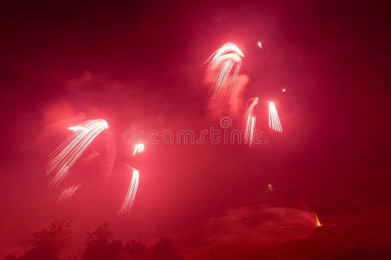 Bright Red Fireworks with Wake Effect Over Trees Silhouette Stock Photo ...