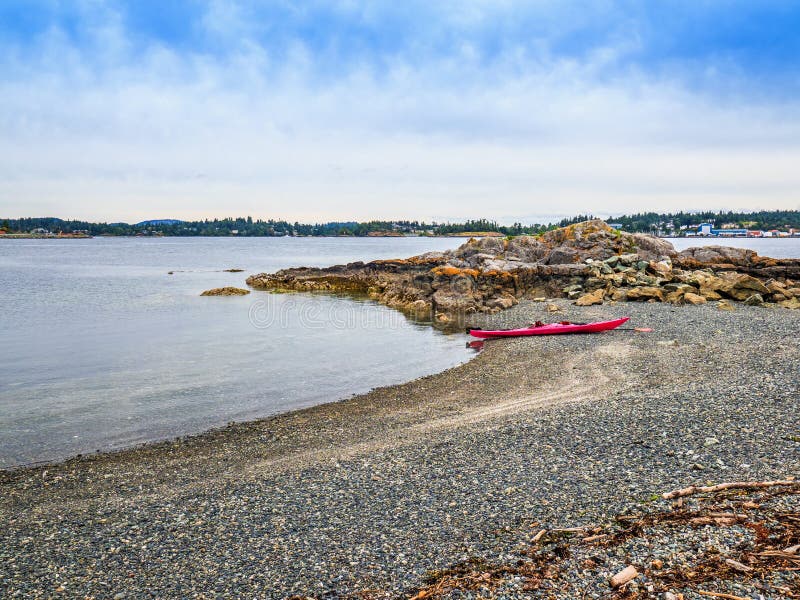 Bright Red Kayak on a Pebble Ocean Beach Stock Photo - Image of ...