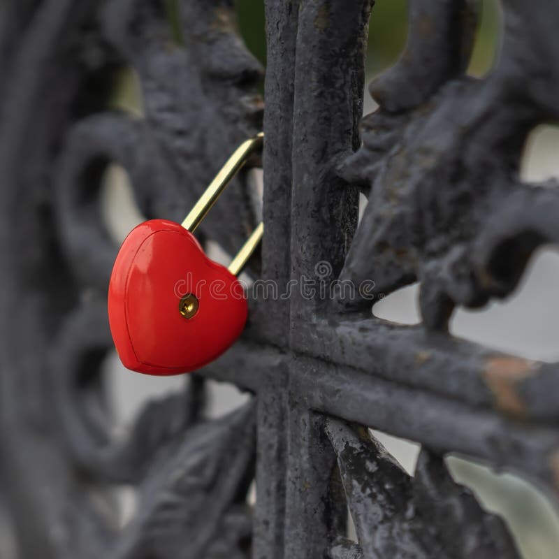 Bright Red Lock in the Shape of a Heart on a Black Old Railing of the ...
