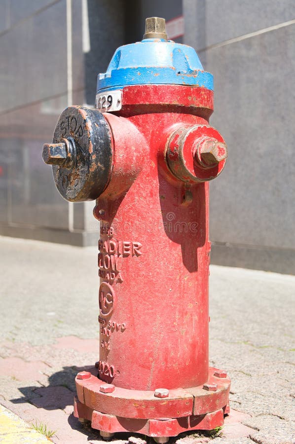 Bright Red Painted Fire Hydrant with Blue Cap on an Urban Sidewalk on a ...