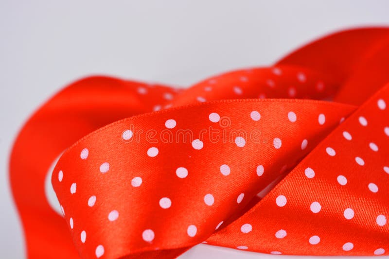 Bright Red Satin Ribbons with White Polka Dots are Located on a White ...