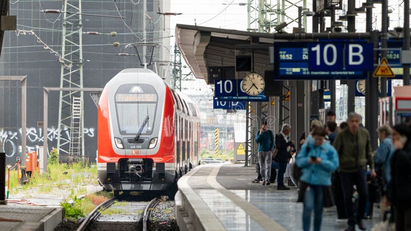 Bright Red Train Pulling into a Bustling Station As People Patiently Wait To Board it. Editorial ...
