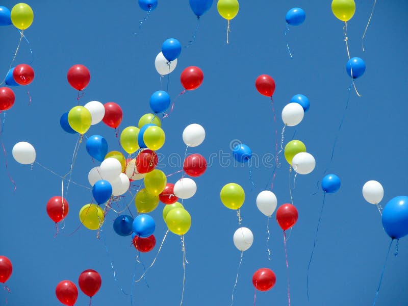 Bright Red, Yellow, Blue, And White Balloons Released Into A Blue Sky ...