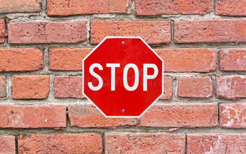 Bright Stop Sign Attached To Large Brick Siding Stock Photo - Image of ...