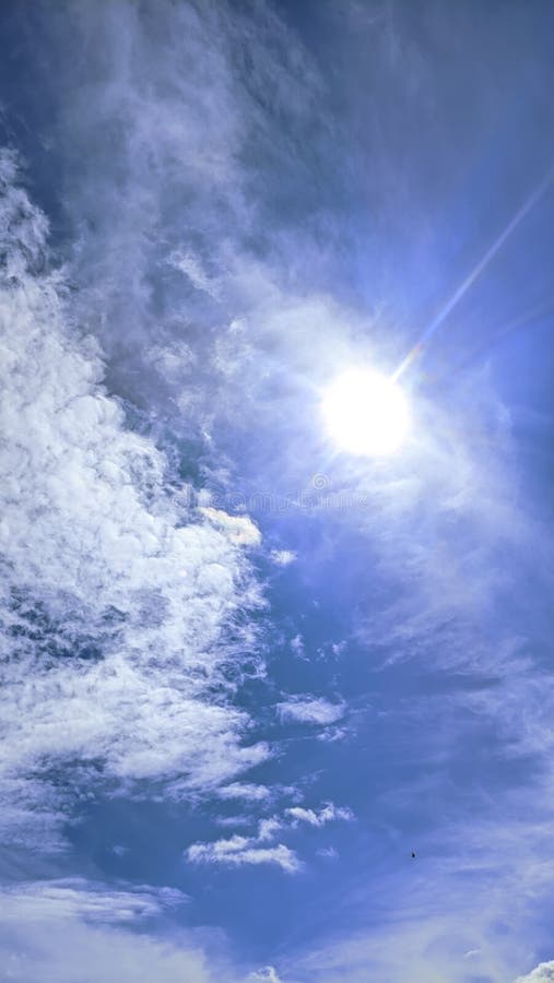 Bright Sun and Soft Clouds in a Clear Blue Sky Stock Image - Image of ...
