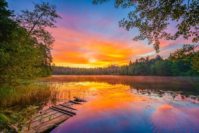 Bright sunrise on a lake stock image. Image of haze - 116545719