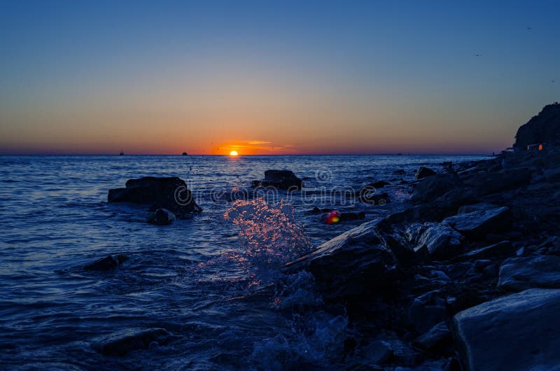 Bright Sunset Under the Sea with Waves Splashes. Stock Image - Image of ...