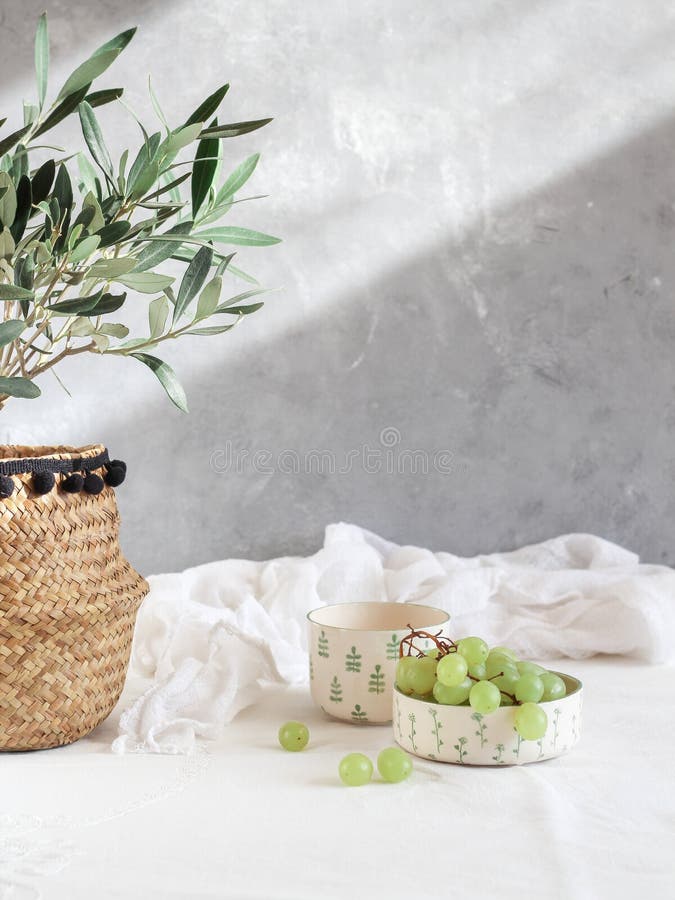 Bright Table Setting with Green Grapes and Olive Tree in Pot Stock ...