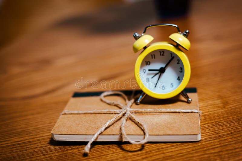 A Bright Yellow Alarm Clock and Notebook with String Create a Cozy ...