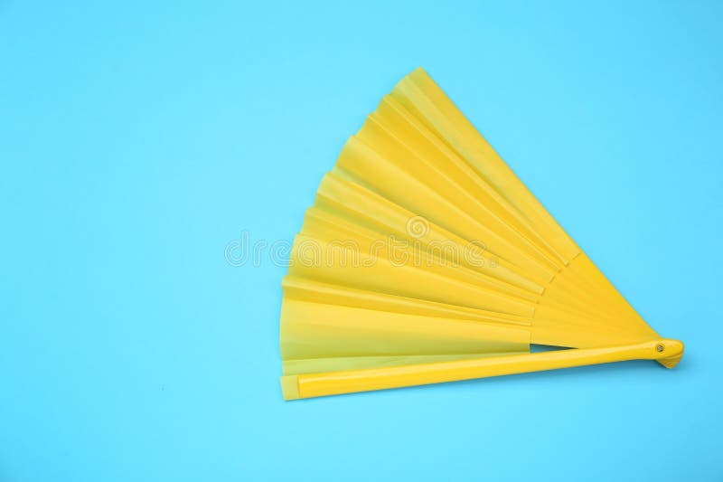 Bright Yellow Hand Fan on Light Blue Background, Top View. Space for ...