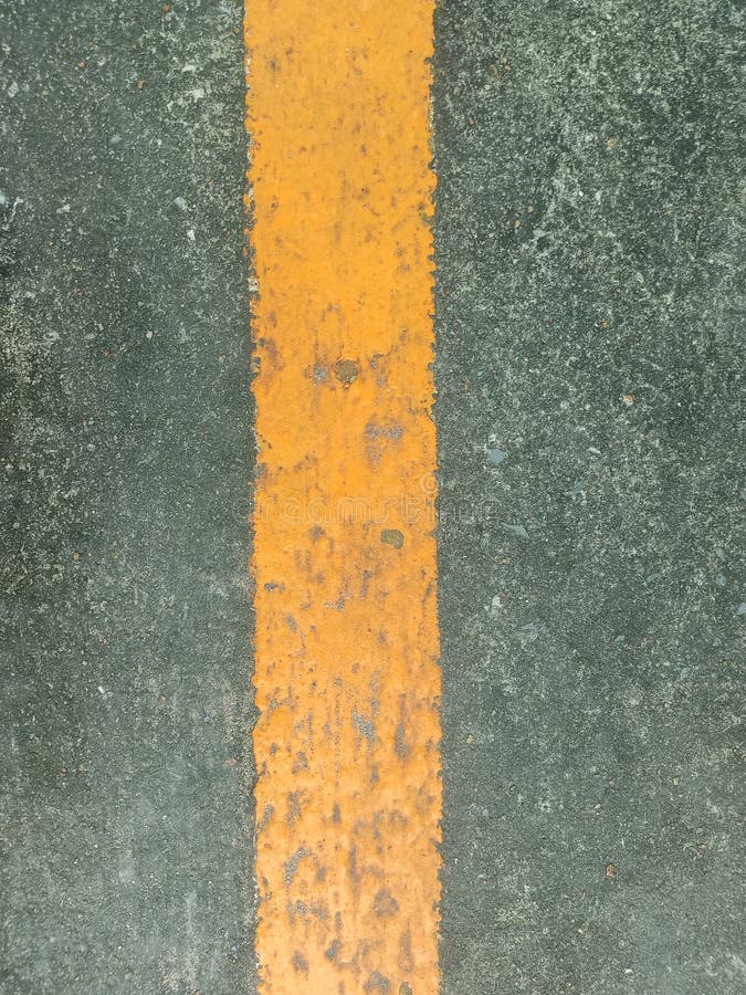 A Bright Yellow Line Painted on a Rough, Textured Gray Surface. Stock ...