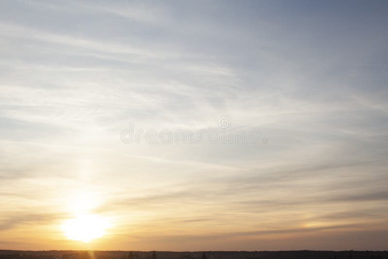 The Bright Yellow Sun Shines through the High Clouds during Sunset. a ...