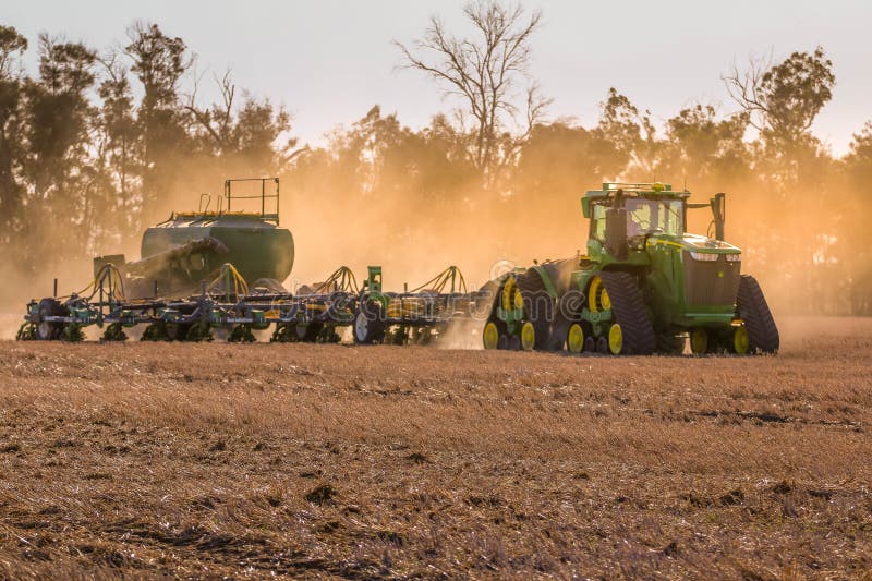 A Tractor Pulls Plow Across the Field while the Sun Shines on it ...