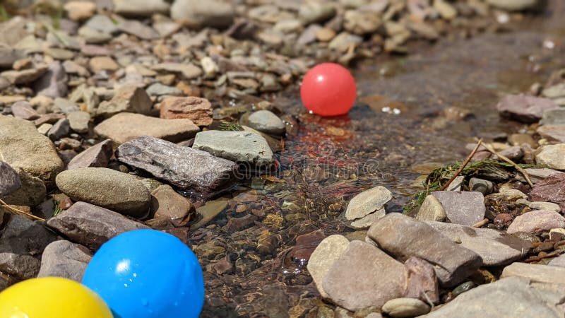 Brightly Coloured Plastic Balls Floating Down the Stream on the River ...