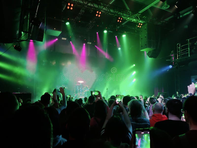 Brightly Lit Scene of a Rock Concert. There are Many Spectators in the ...