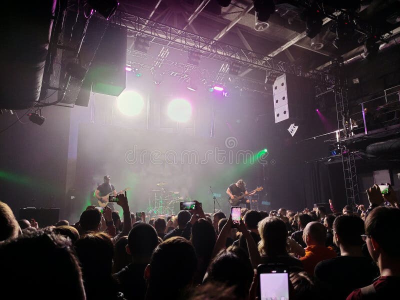 Brightly Lit Scene of a Rock Concert. There are Many Spectators in the ...