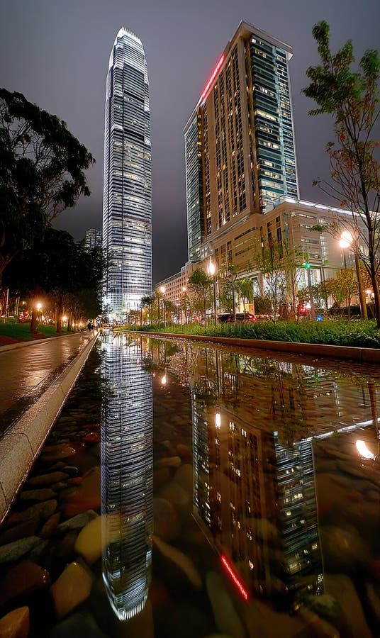 Brightly Lit Skyscrapers Tower Above a Serene Waterway, Their ...