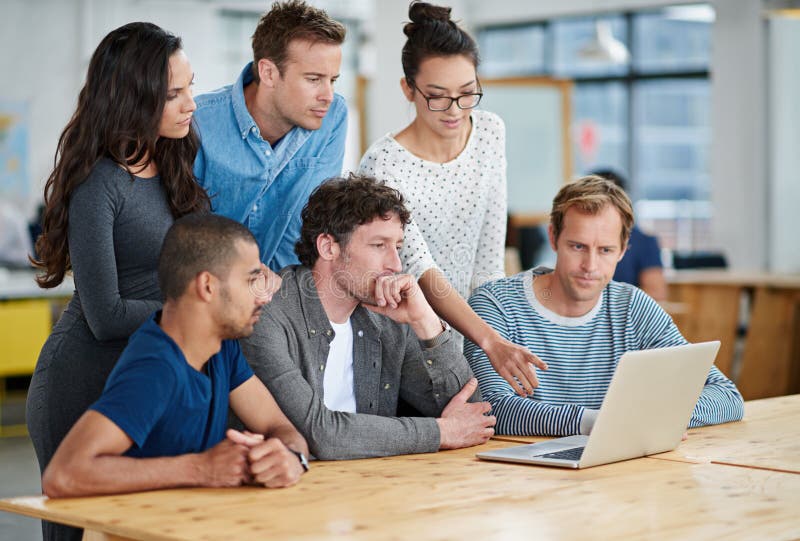 Bringing Many Ideas To the Table. a Group of Colleagues Using a Laptop ...
