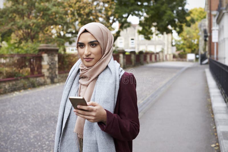 British Muslim Woman Using Mobile Phone in Urban Setting Stock Photo ...