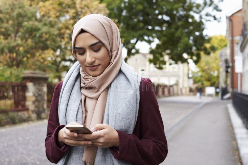 British Muslim Woman Using Mobile Phone in Urban Setting Stock Photo ...