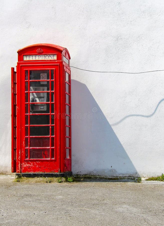 British Red Telephone Box in Sunlight by White Building Stock Image ...