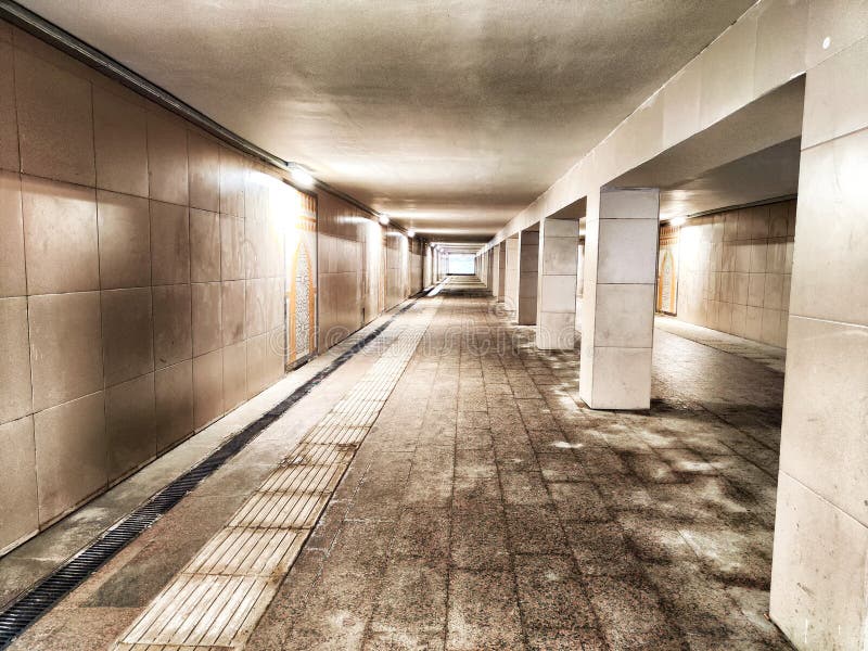 A Broad Underground Passageway Features Clean Tiles and Bright Lights ...