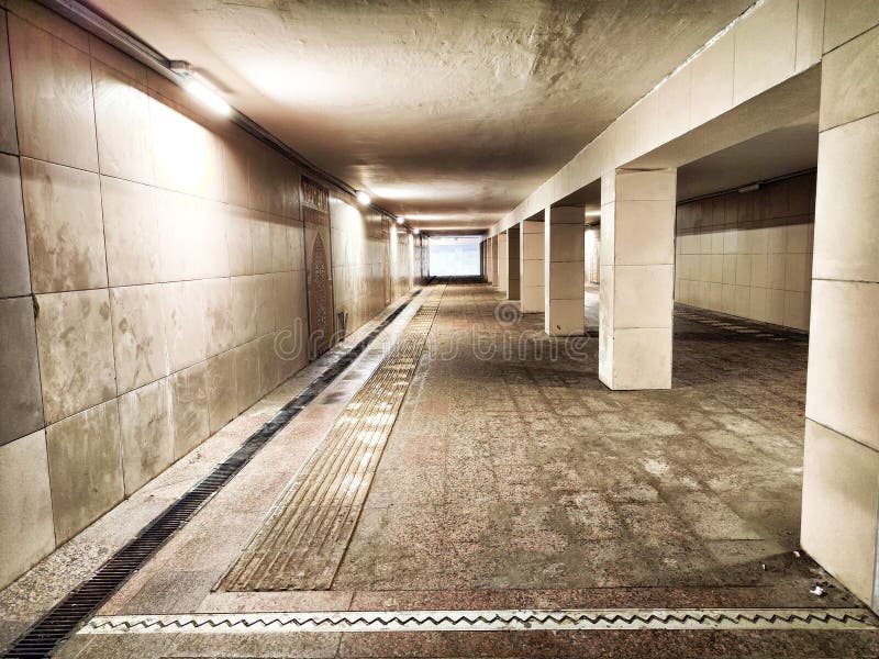 A Broad Underground Passageway Features Clean Tiles and Bright Lights ...