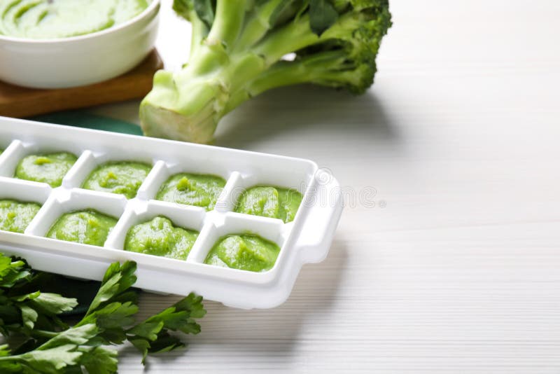 Broccoli Puree in Ice Cube Tray and Ingredients on White Wooden Table ...
