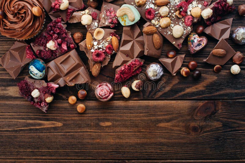 Broken Bars of Chocolate with Nuts and Chocolate Candies on Rust Stock ...