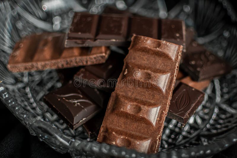 Broken Bars of Different Chocolate Stacked on a Light Background Stock ...
