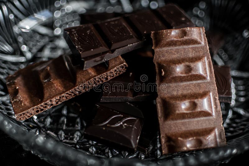Broken Bars of Different Chocolate Stacked on a Light Background Stock ...