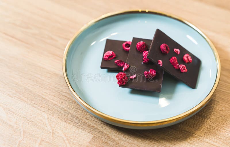 Broken Bars of Premium Craft Chocolate with Dried Raspberry on a Plate ...