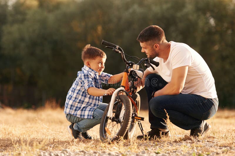 Broken Bike, Process of Fixing it. Dad with Son are with Bicycle on the ...