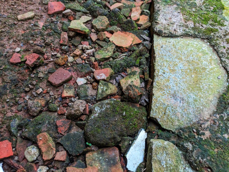 Broken Bricks and Gravel beside a Moss-covered Stone Wall. Stock Image ...
