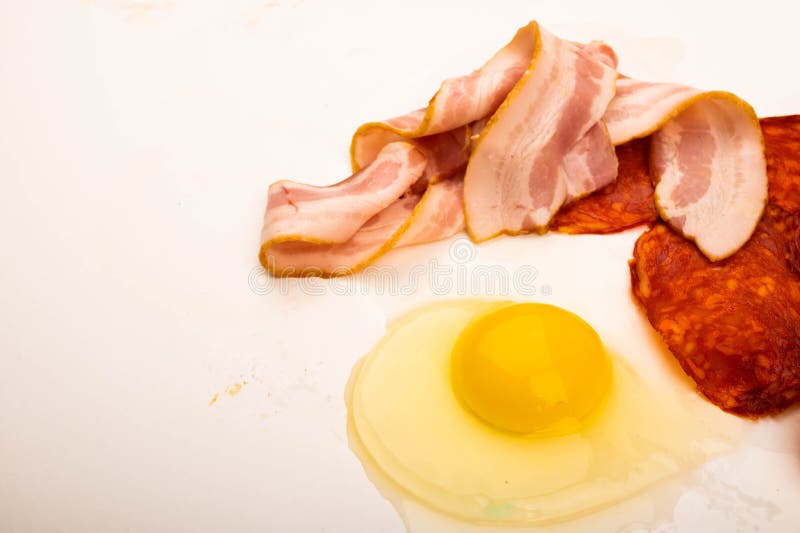 A Broken Chicken Egg without a Shell, Slices of Sausage and Bacon and ...