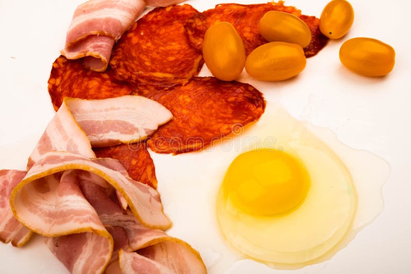 A Broken Chicken Egg without a Shell, Slices of Sausage and Bacon and ...