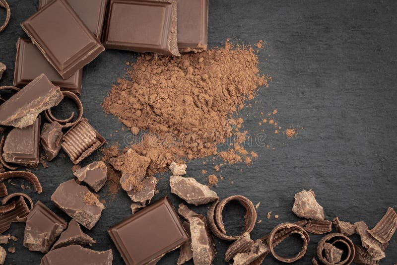 Broken Chocolate Pieces and Cocoa Powder on a Dark Background. Top View ...