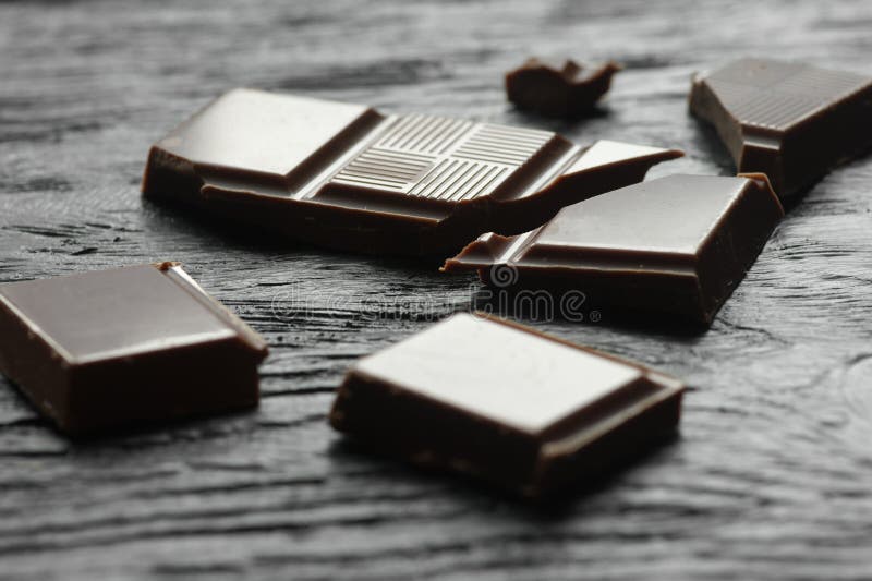 A Broken Bar of Dark Chocolate on a Black Table. the Concept of ...