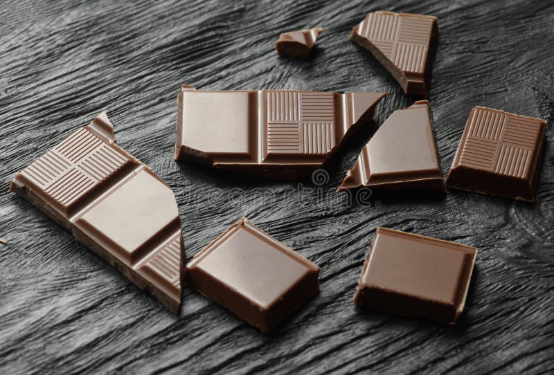 A Broken Bar of Dark Chocolate on a Black Table. the Concept of ...