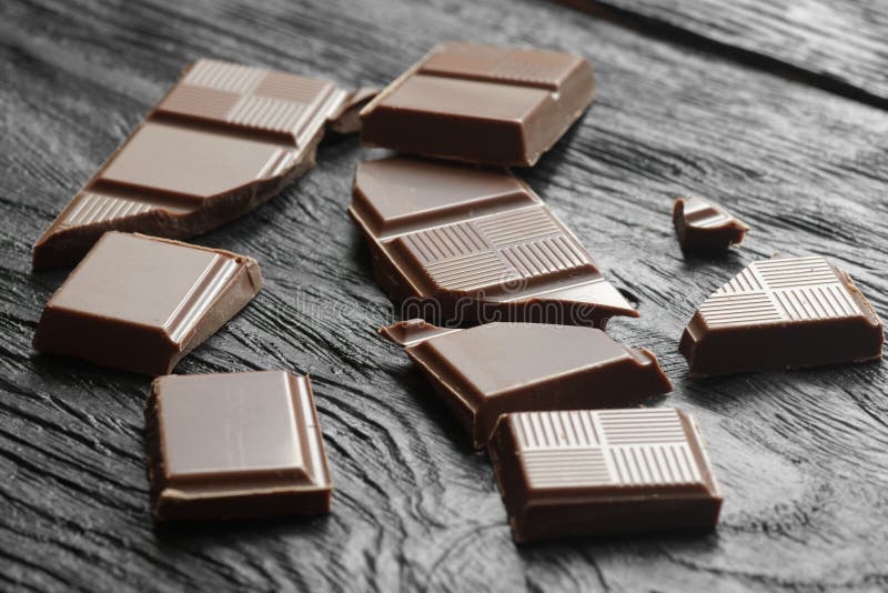 A Broken Bar of Dark Chocolate on a Black Table. the Concept of ...