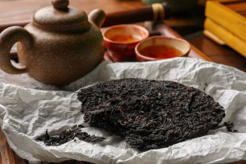 Disc Shaped Traditional Chinese Pu-erh Tea and Fresh Leaves Isolated on ...